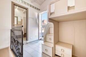 Um corredor moderno e bem iluminado, com escada, guarda-roupa de madeira e espelho.