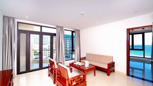 Uma sala de estar moderna com um sofá, uma mesa de centro de madeira e uma mesa de jantar.