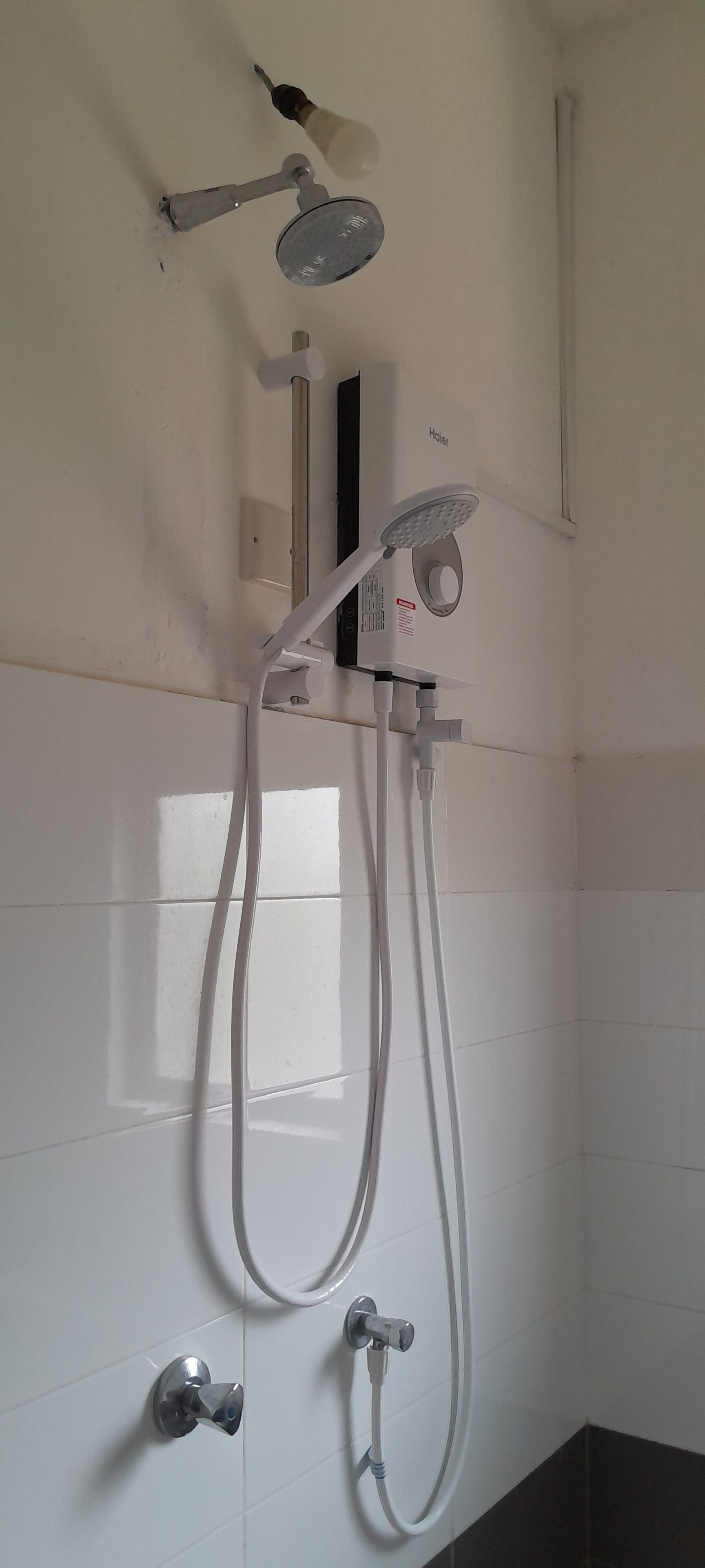 Um banheiro com chuveiro, vaso sanitário e pia.