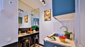 Uma cozinha moderna com bancada de madeira, dois banquetes, uma pia e um espelho.