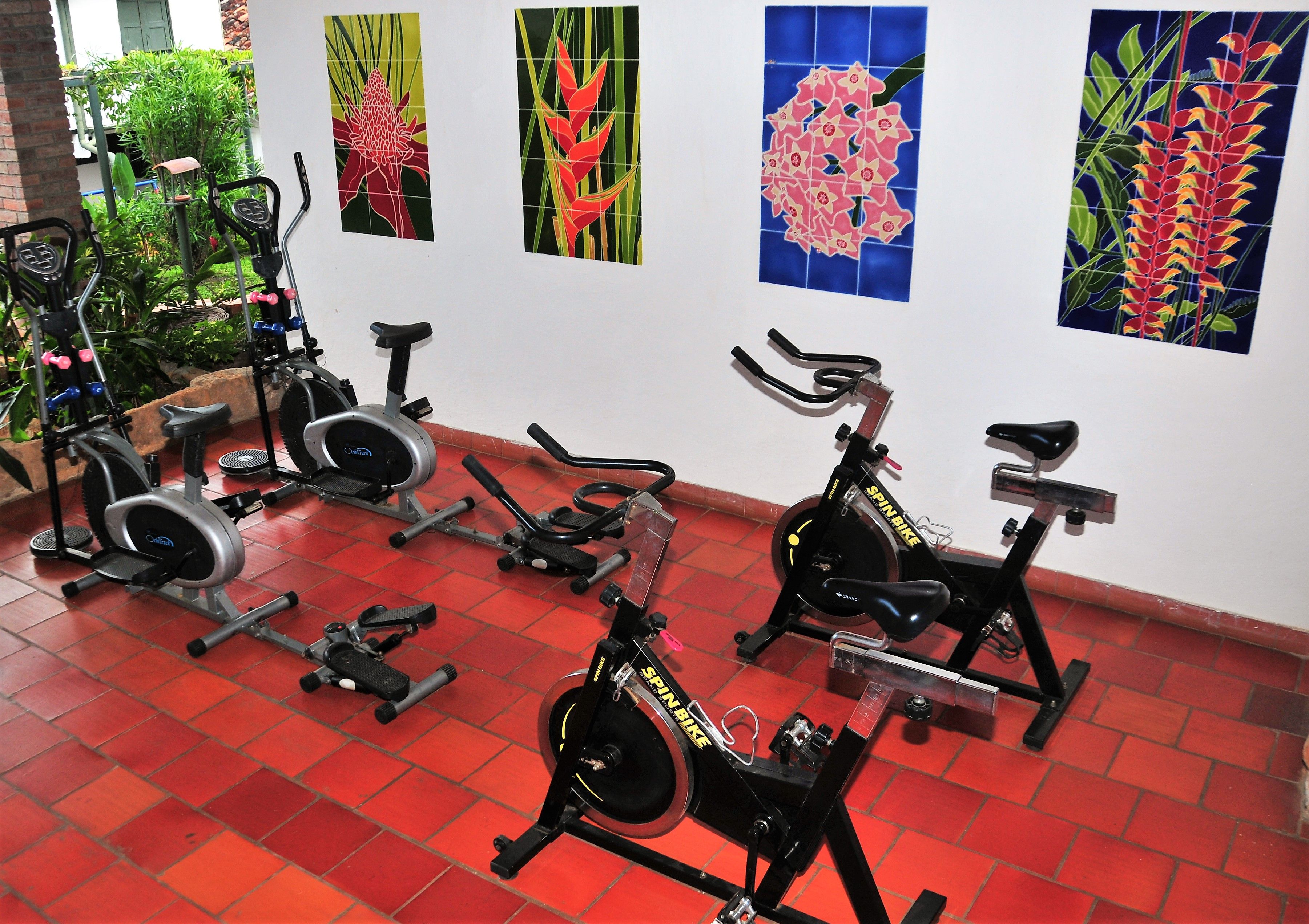 Academia com bicicletas ergométricas, equipamentos de ginástica e bolas de exercício.