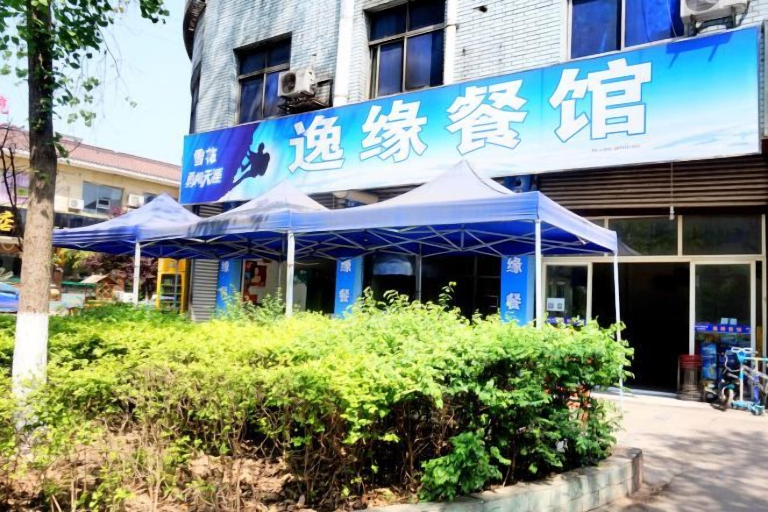 Um edifício com toldo azul e placas indicando um restaurante.