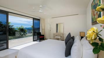 Quarto de hotel moderno com uma cama grande, uma escrivaninha e vista para o exterior.