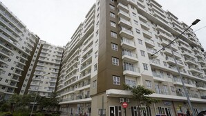 Um edifício residencial com vários andares, varandas, placa de estacionamento e indicação de área de estacionamento.