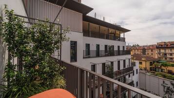 Um edifício residencial de vários andares com varandas, design arquitetônico moderno e vista para edifícios ao redor.