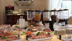 Buffet com diversos alimentos e recipientes.