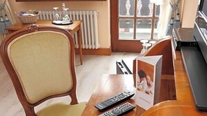 Uma mesa de jantar de madeira com uma cadeira, um controle remoto e um cartão em cima.