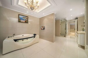 Um banheiro moderno com uma banheira de pés, um candelabro e um quadro na parede.