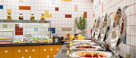 Uma área de buffet com diversos pontos de comida e uma parede colorida revestida em azulejos.
