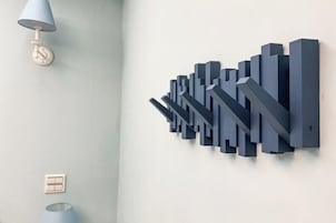Uma parede moderna com uma série de painéis verticais retangulares dispostos em padrão escalonado.