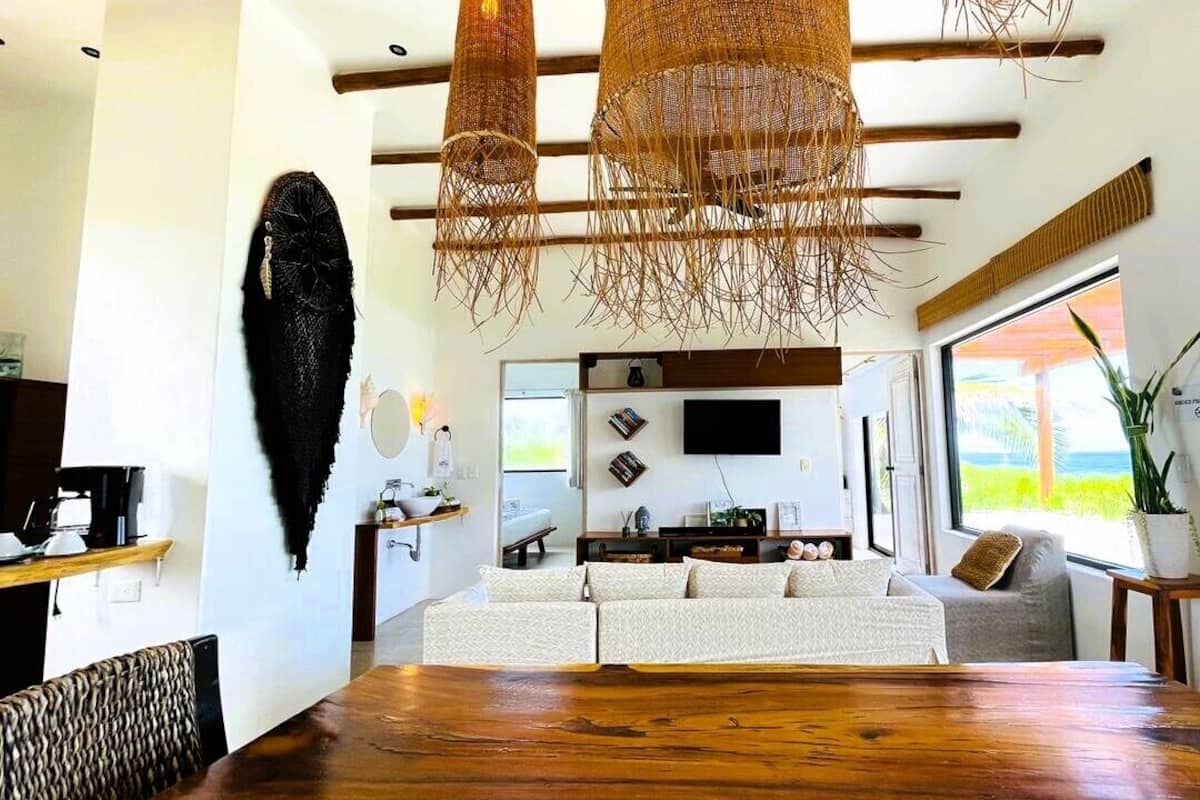 Uma sala de estar moderna com uma mesa de jantar de madeira, um sofá e uma televisão.