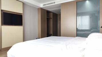 Quarto de hotel com uma cama, televisão fixada na parede e armário com porta deslizante.