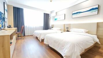 Quarto de hotel com duas camas, uma escrivaninha e uma cadeira.