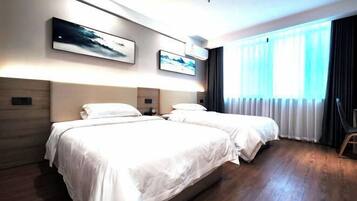 Quarto de hotel com duas camas, uma janela grande com cortinas e uma obra de arte na parede.