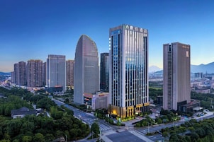 Paisagem urbana com edifícios modernos altos, céu limpo e ambiente urbano bem cuidado.