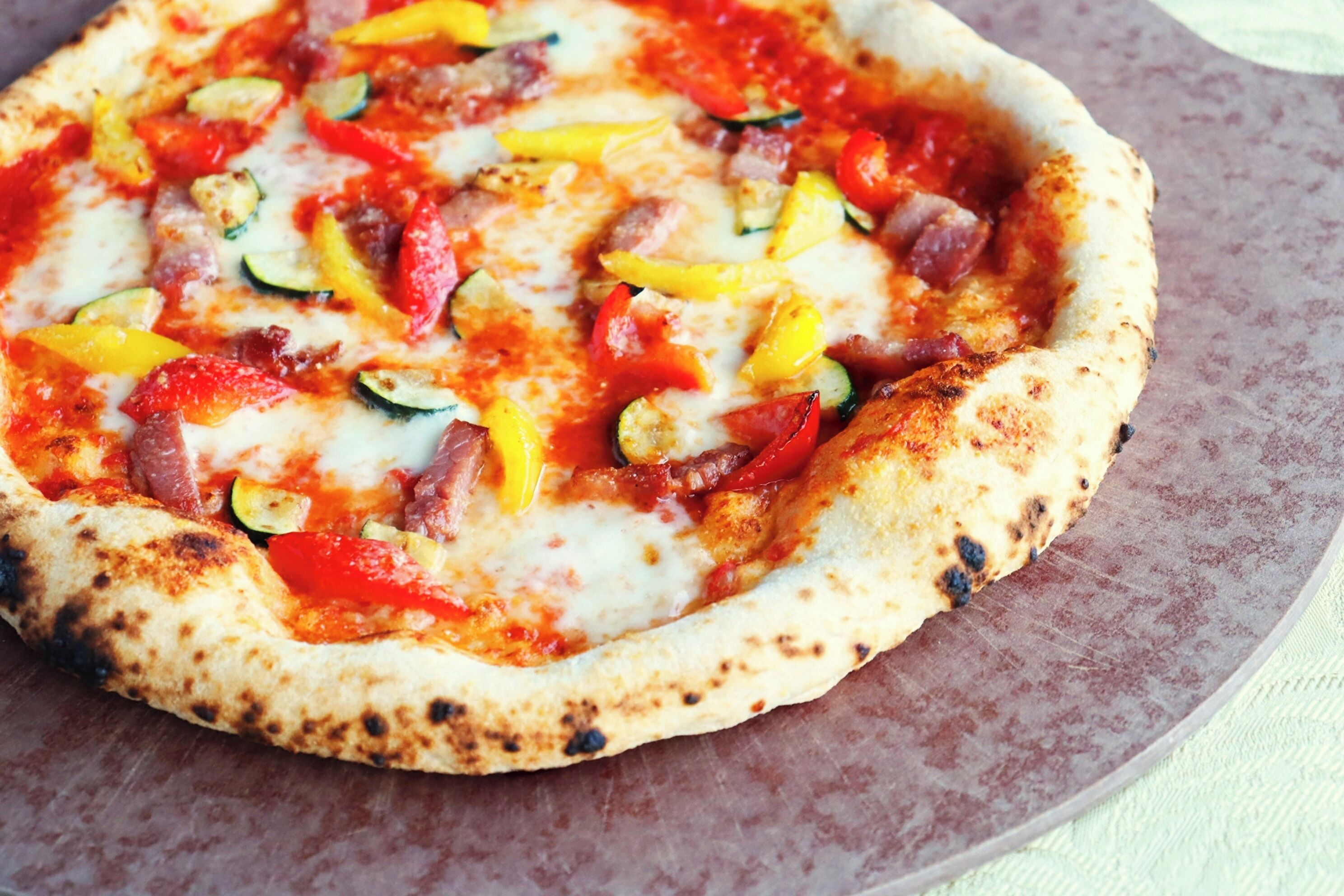 Pizza com vários vegetais e queijo em um prato redondo.