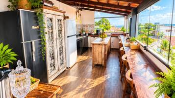 Uma cozinha moderna com teto de madeira, grandes janelas e vista para o exterior.
