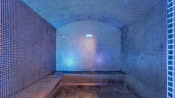 Estrutura em forma de túnel com padrão de grade nas paredes e no chão, que leva a um ponto central.