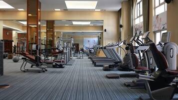 Uma academia com diversos equipamentos de exercício, incluindo esteiras e aparelhos de musculação.