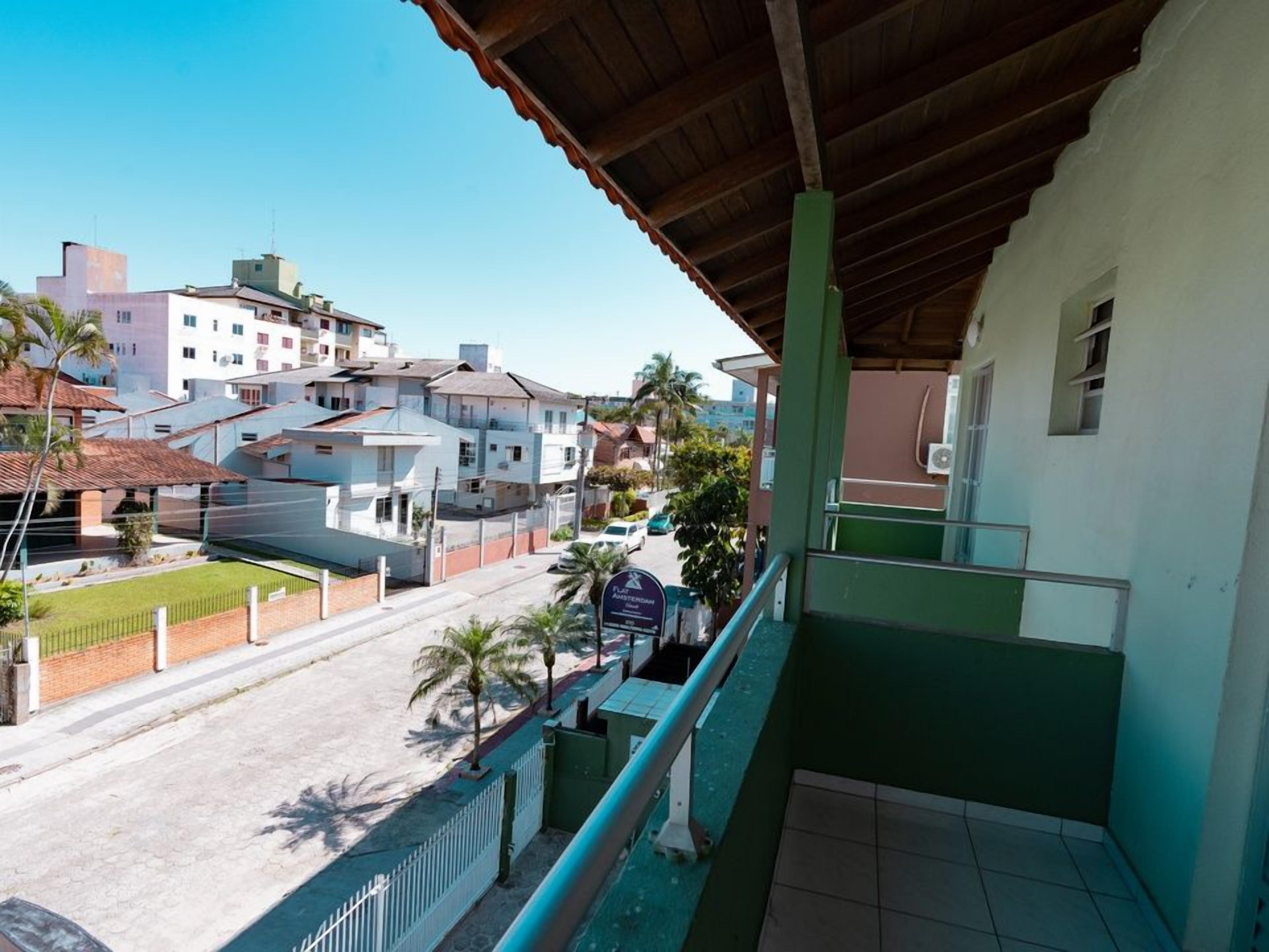 Uma varanda com vista para uma área residencial, incluindo casas e uma rua.