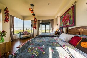 Quarto com uma cama grande, vista do céu e uma janela.
