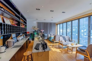 Espaço de escritório moderno com uma mesa comprida, computador e área de estar.