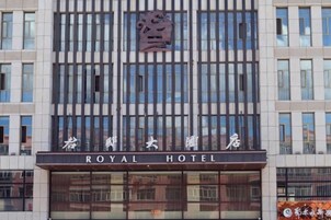 Fachada de hotel com uma placa indicando 'ROYAL HOTEL' e caracteres chineses acima.