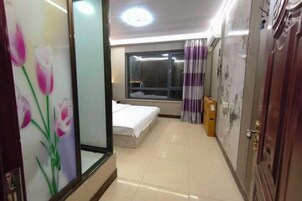 Quarto de hotel com cama, janela, cortina e porta.