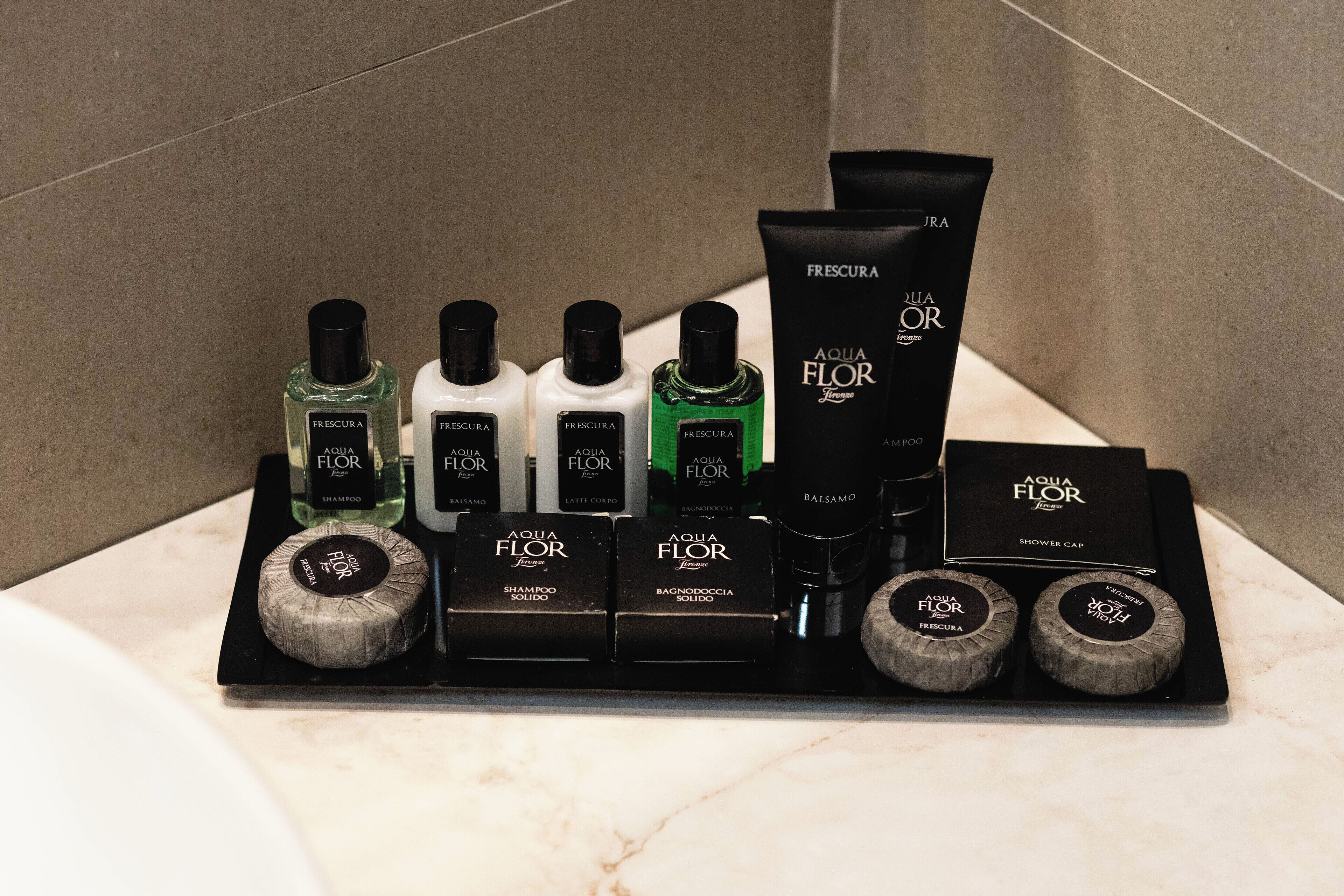 Uma toucador de banheiro com artigos de higiene pessoal, incluindo shampoo, condicionador e gel de banho.