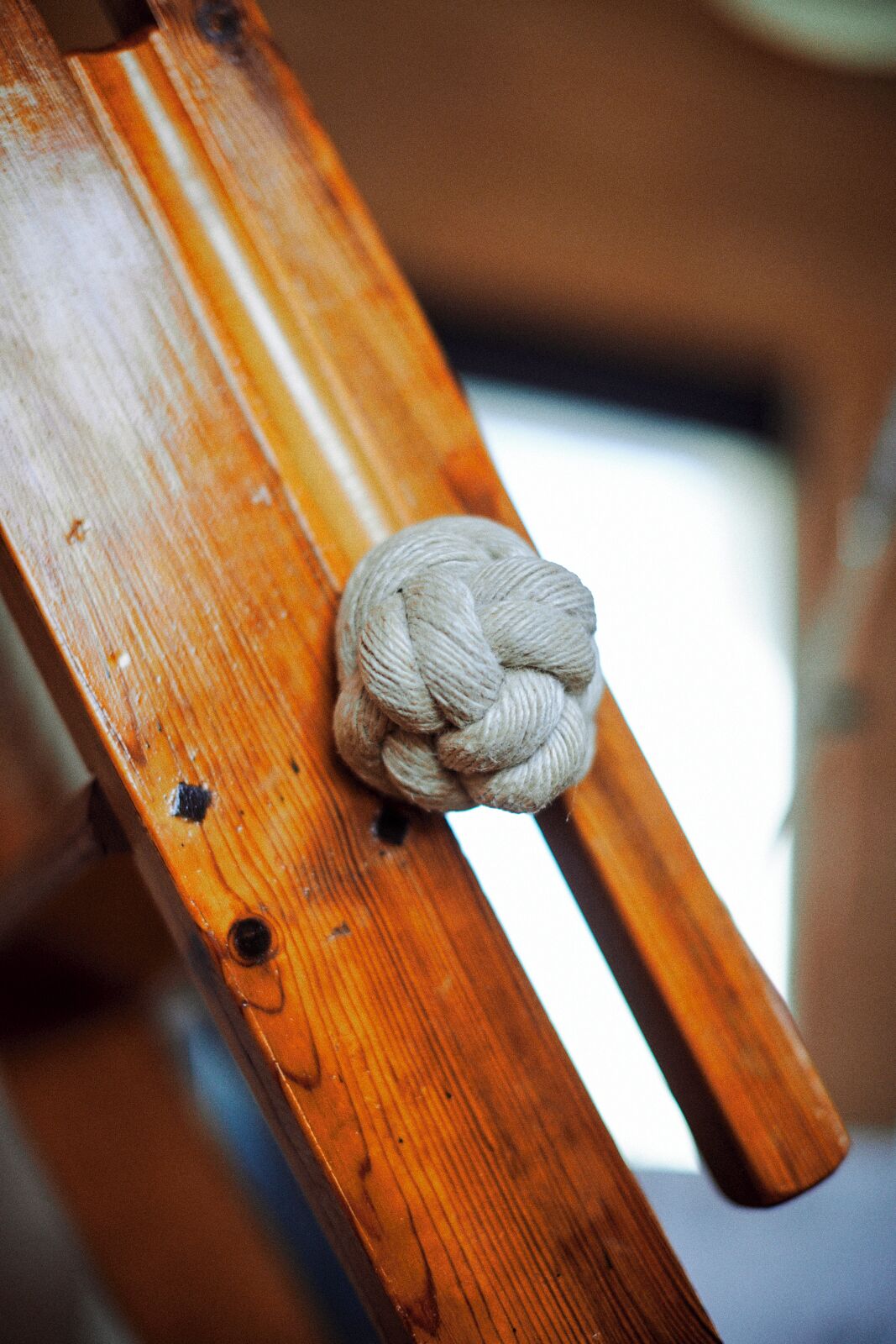 Close-up de uma cadeira de madeira com uma corda amarrada em nó.