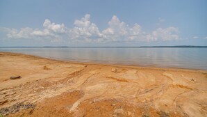 Uma praia com céu claro e águas calmas.