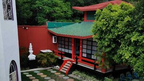Uma carrinha branca estacionada em frente a um edifício com telhado vermelho e um jardim no telhado verde.