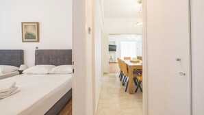 Quarto de hotel com cama, escrivaninha e área de refeições.