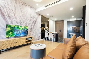 Uma sala de estar moderna com televisão, mesa de centro redonda e sofá.