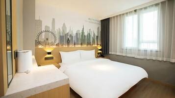 Quarto de hotel com cama, mesa de cabeceira, luminária, espelho, janela com cortinas e um mural com vista para o horizonte urbano.
