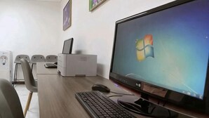 Uma mesa de escritório com monitor, teclado e rato.