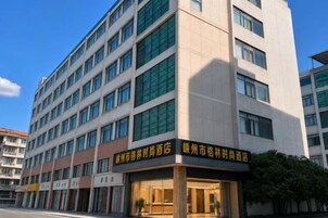 Um hotel com vários andares, fachada moderna, janelas amplas e placas com escrita em idioma estrangeiro.