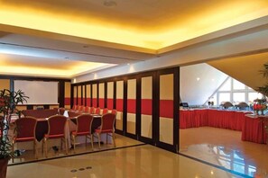 Uma sala de conferências com uma mesa comprida e cadeiras, uma tela de projetor e um amplo janelão.