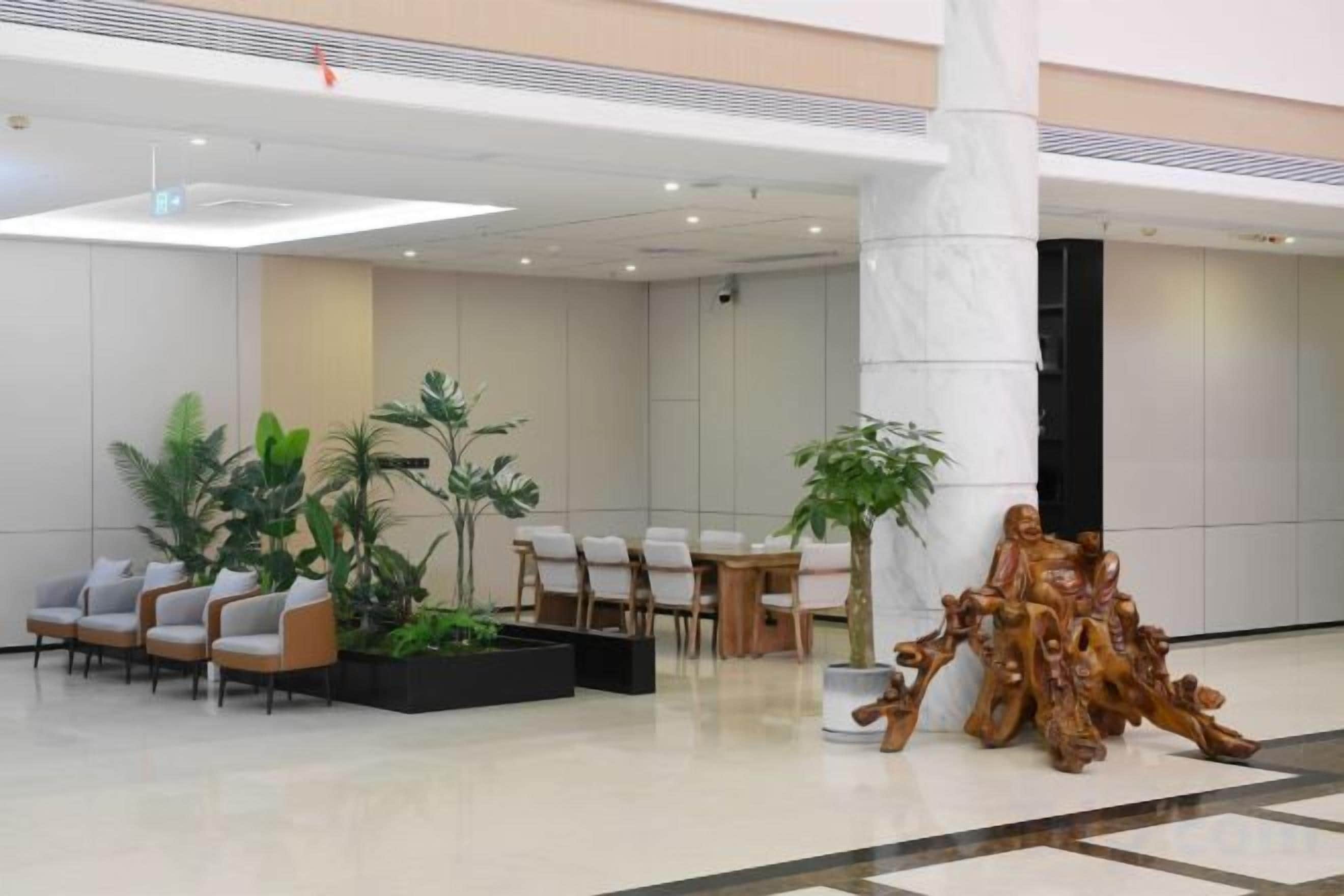 Um hall com assentos, um pilar grande e uma escultura decorativa de madeira.