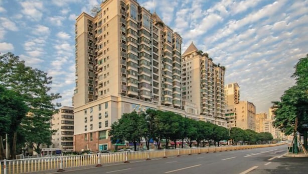 Um edifício residencial alto, com várias sacadas e design arquitetônico moderno.
