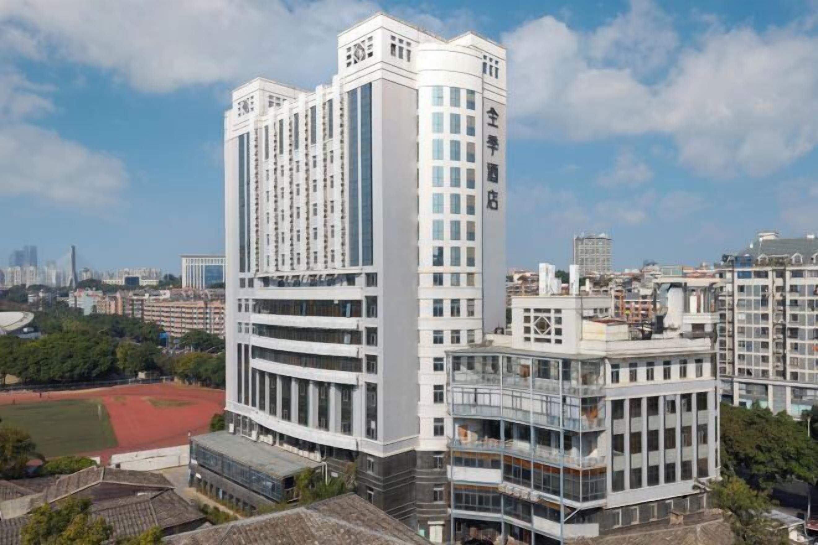 Um edifício alto com vários andares, grandes janelas e uma placa de destaque.