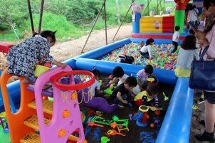 Uma área de recreação infantil com piscina de bolinhas, escorregadores e estruturas de escalada.