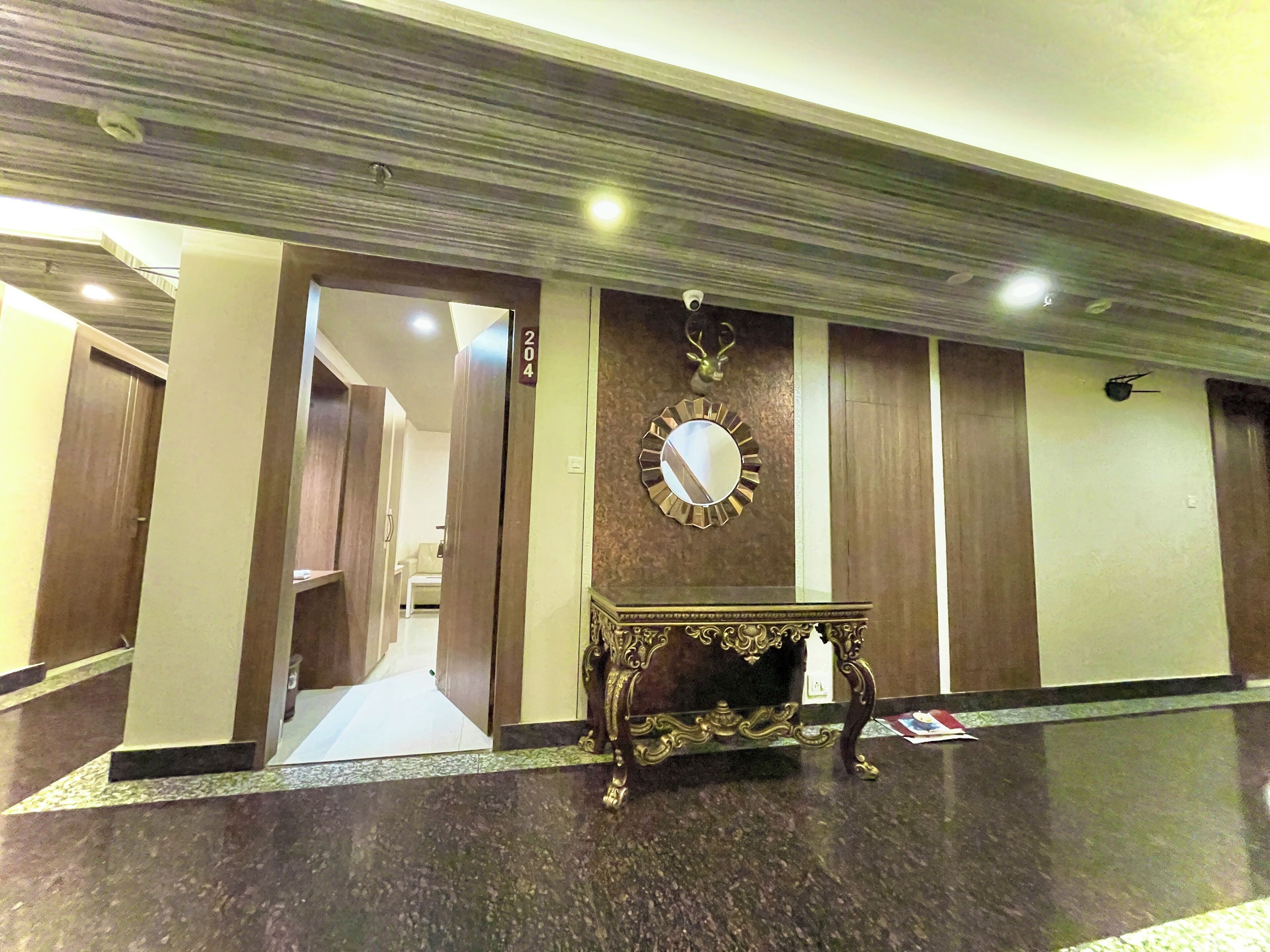 Um hall de entrada com piso de mármore, uma mesa decorativa e um espelho fixado na parede.