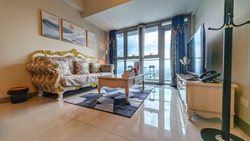 Apartamento luxo, 1 quarto, cozinha, vista para a cidade | Área de estar | Smart TV 50 polegadas com canais digitais, Netflix