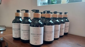 Garrafas pretas em linha com etiquetas brancas sobre uma superfície de madeira.