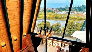 Um quarto espaçoso no estilo loft com uma grande janela com vista para uma paisagem deslumbrante, uma área de estar aconchegante e uma banheira de hidromassagem integrada.