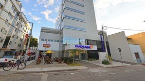 Um hotel moderno com fachada plana, área de estar ao ar livre e entrada visível.