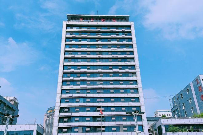 Um edifício de vários andares com design arquitetônico moderno, apresentando uma série de janelas e um telhado plano.