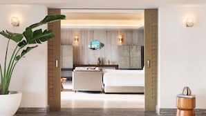 Quarto de hotel moderno com uma cama grande, área de estar e vista da cidade.