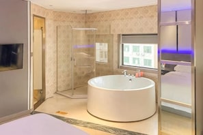 Um banheiro moderno com uma banheira grande, chuveiro de entrada livre e uma cama com vista para a cidade.